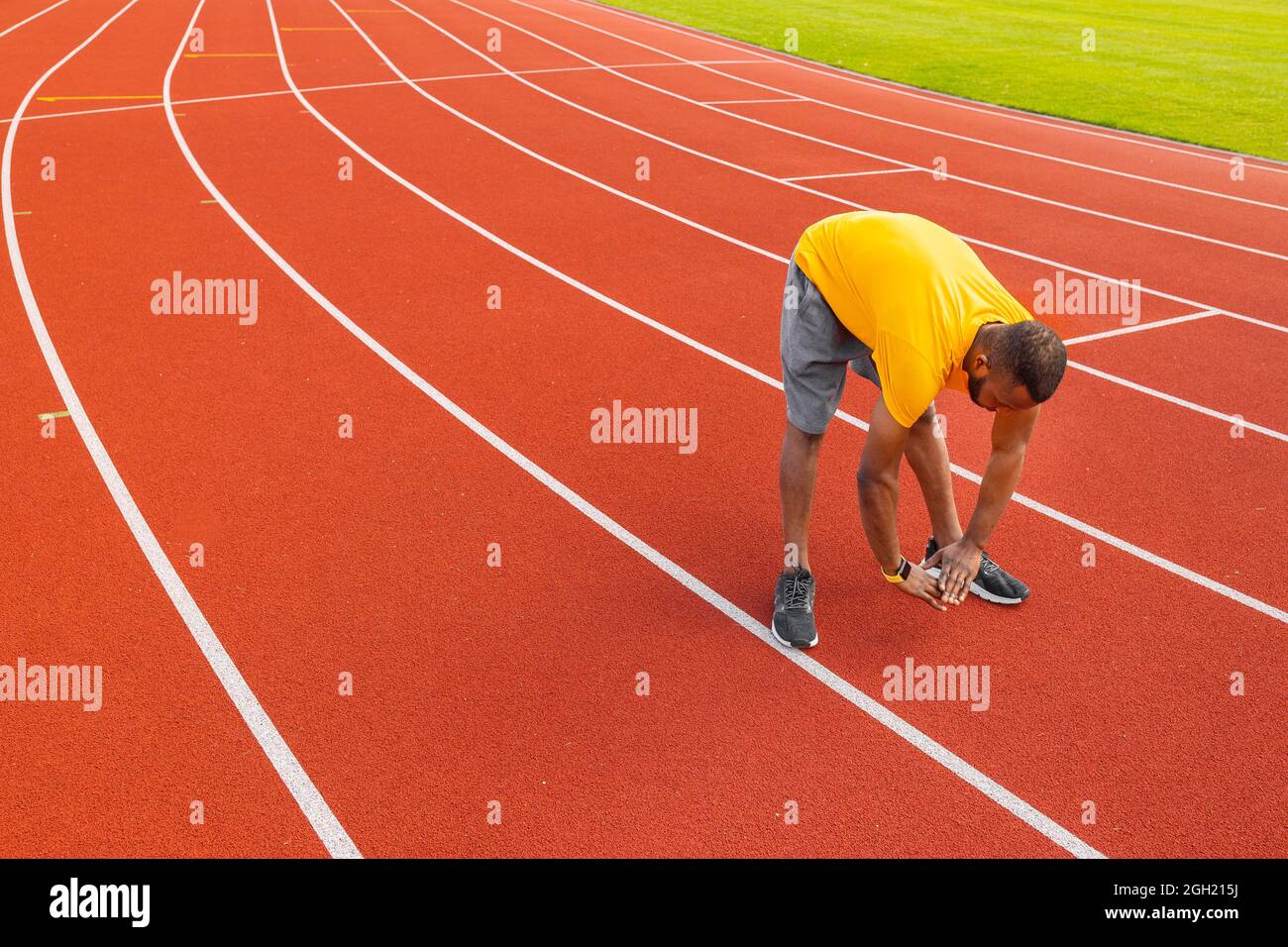 African american male trainer in yellow sportswear standing at stadium ...