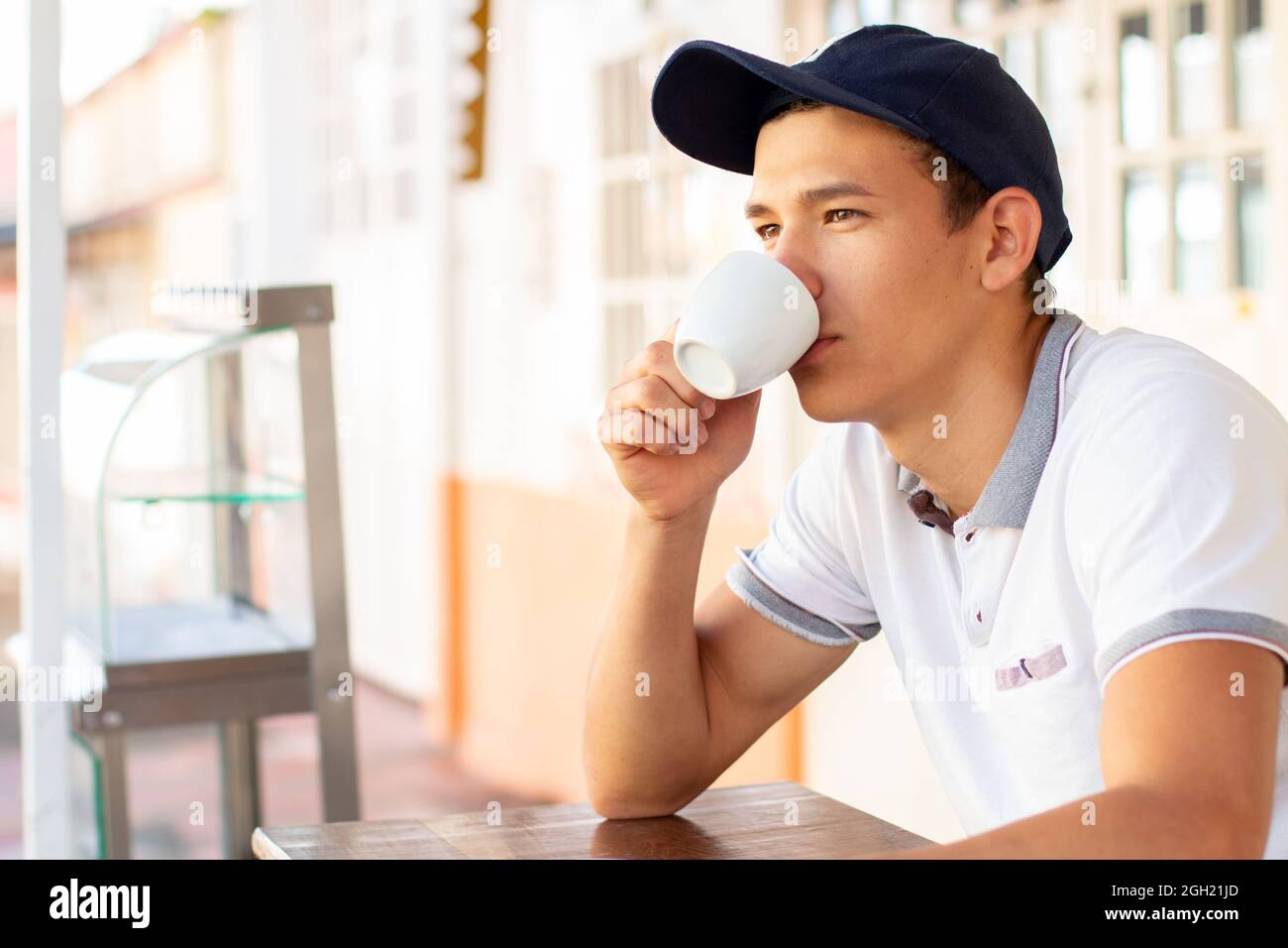 Latin man drinking coffee in a traditional latin place in urban street ...