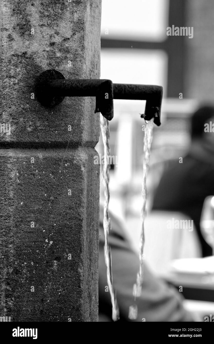 Grayscale shot of an outdoor tap on the column with flowing water Stock ...