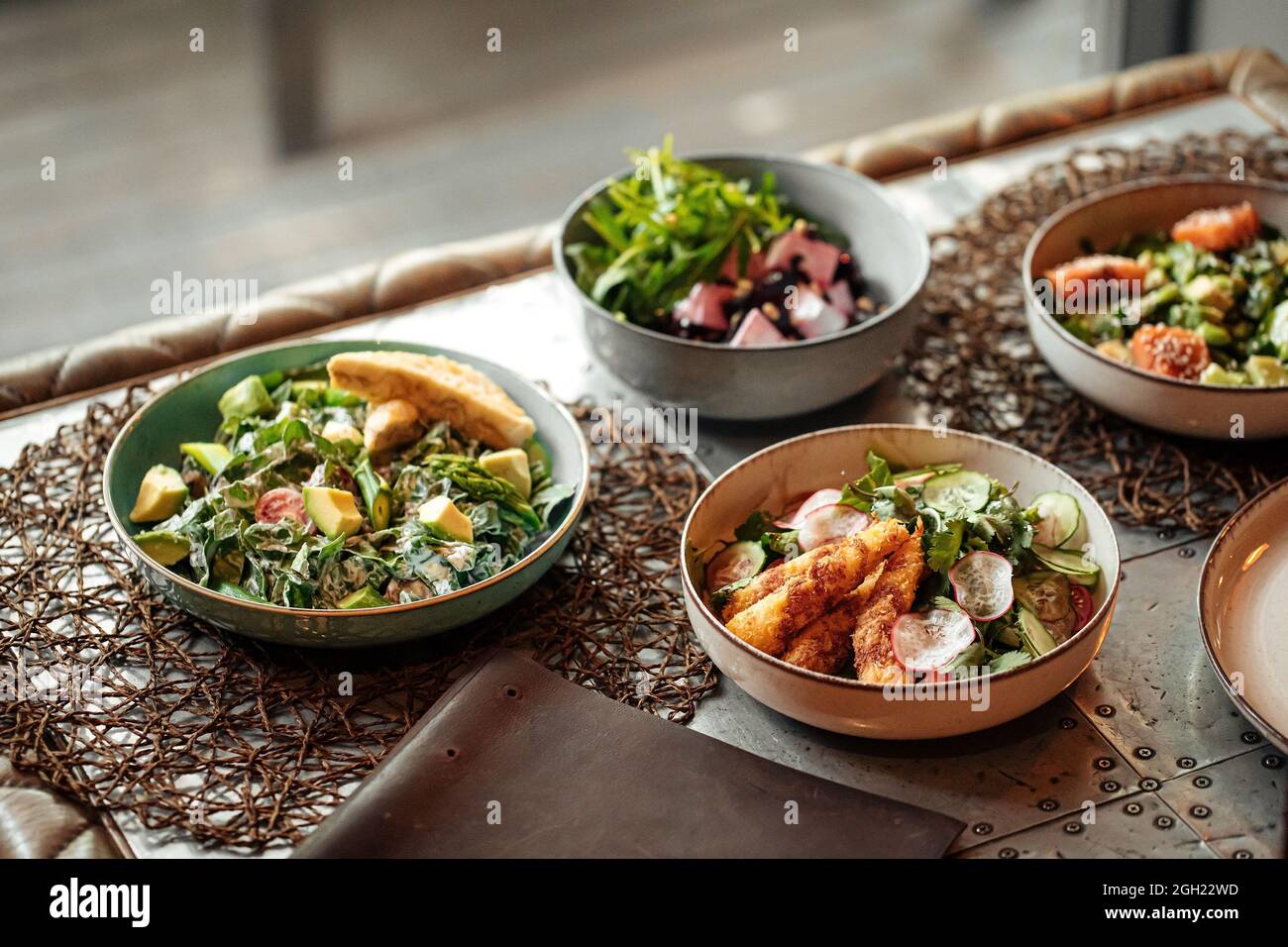 Table served with different gourmet salad bowls Stock Photo - Alamy
