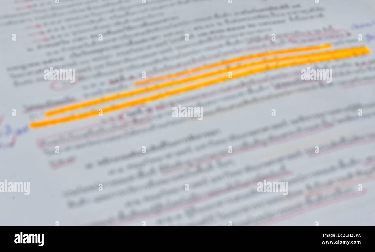 Blurred document with written note and highlighting text. Closeup shot ...