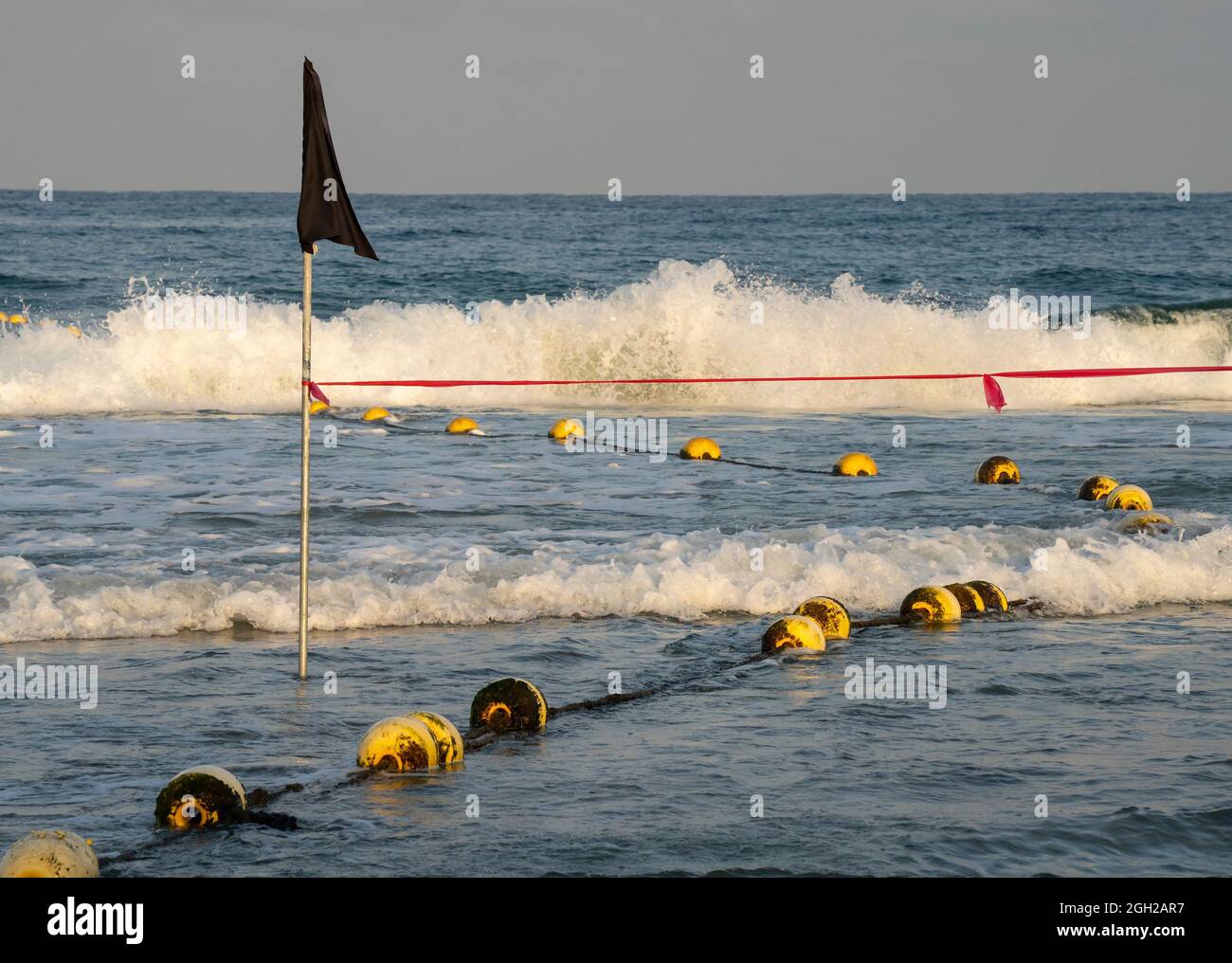 A black flag and a red line as a sign of a rough, wavy sea, where ...