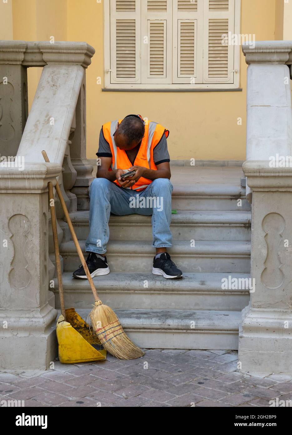 Tel Aviv, Israel - August 16th, 2021: A street cleaner taking a break ...