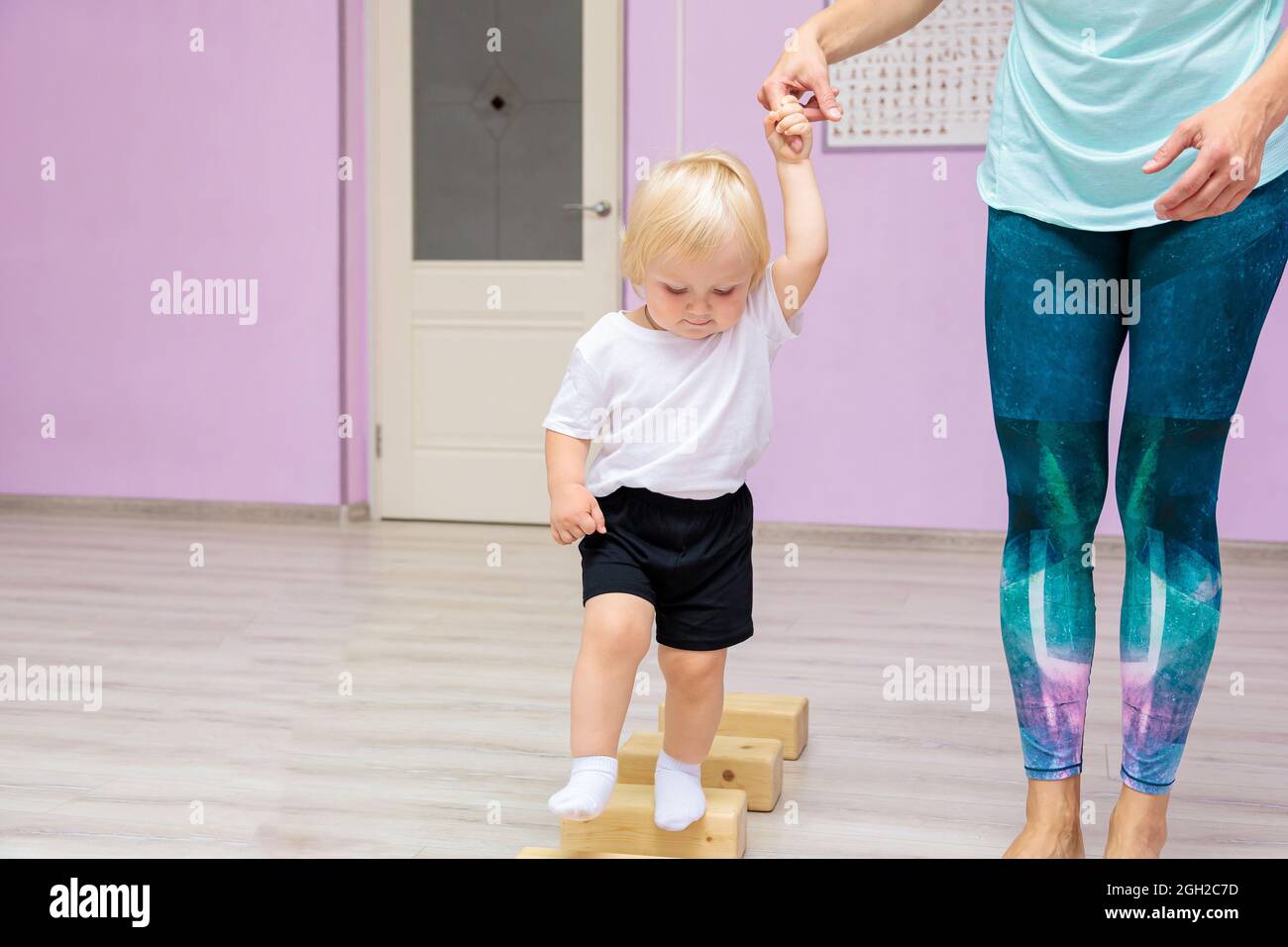 Mom and baby are doing developmental exercises in the gym ...