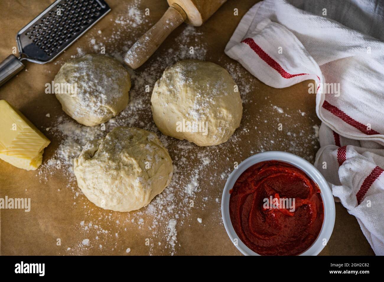 Pizza cooking concept with dough heads on the baking paper Stock Photo ...