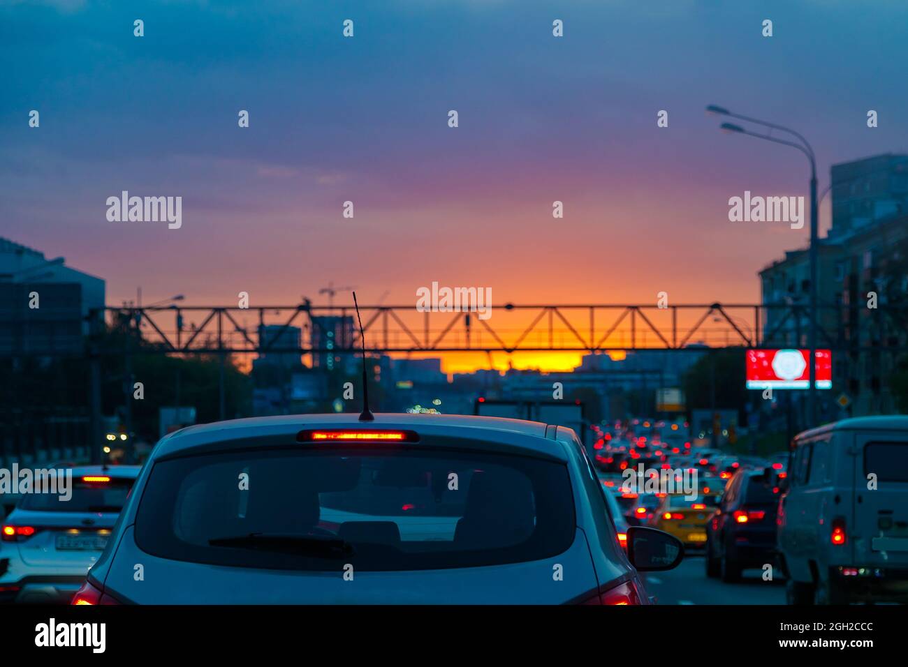 Traffic jam on the road in the evening at sunset in summer. Red lights ...