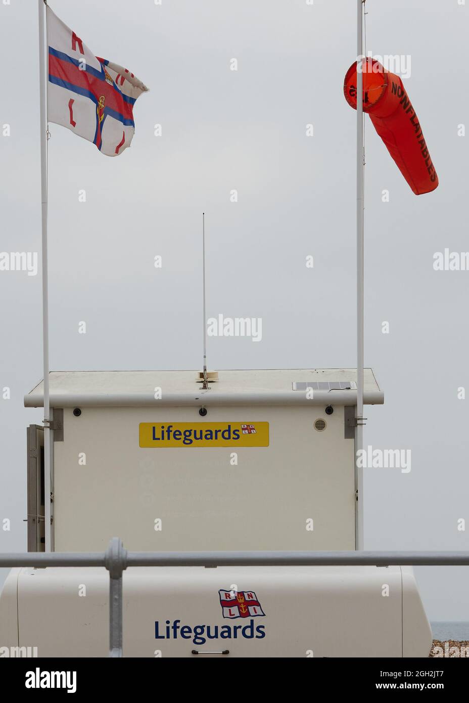 Flags and logo of the RNLI seen on the beach of Bognor Regis in summer ...