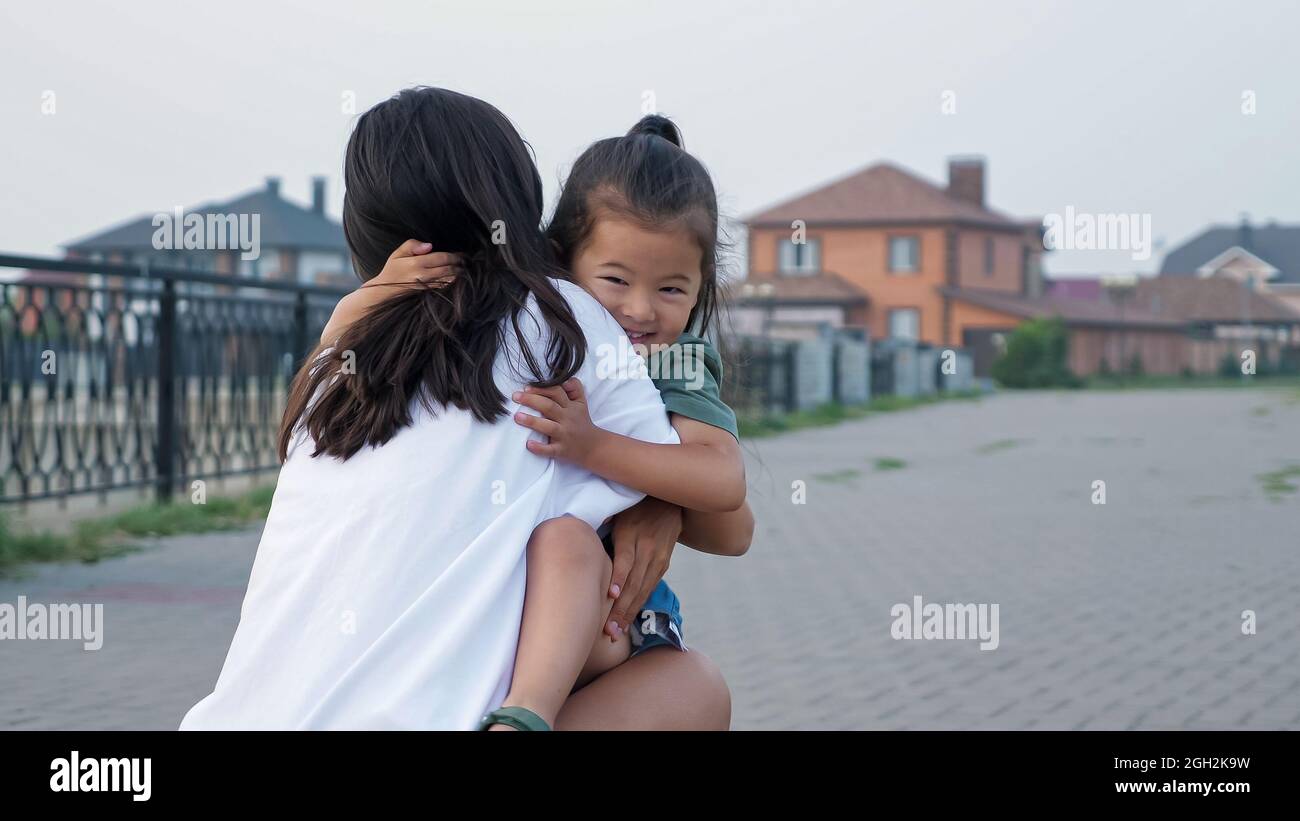 Korean girl runs and jumps in mother arms on embankment Stock Photo - Alamy