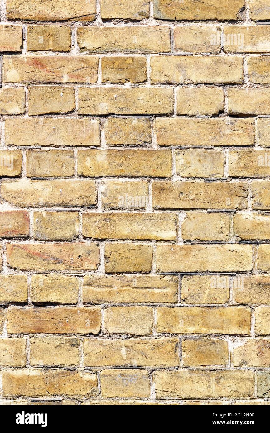 Weathered brick wall texture background in sunlight. Vertical image. A ...