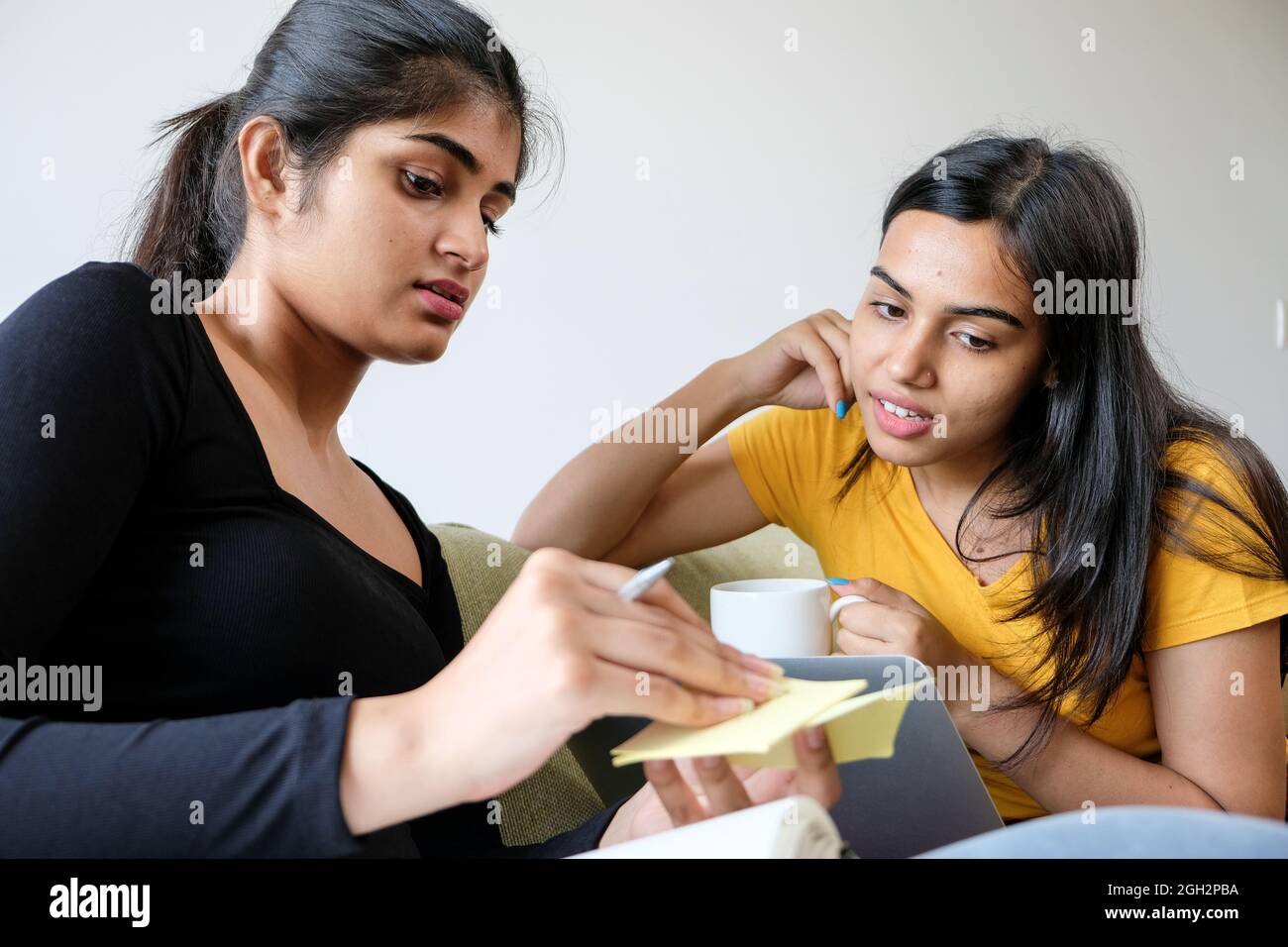 Two young Indian girls having a discussion at home Stock Photo - Alamy