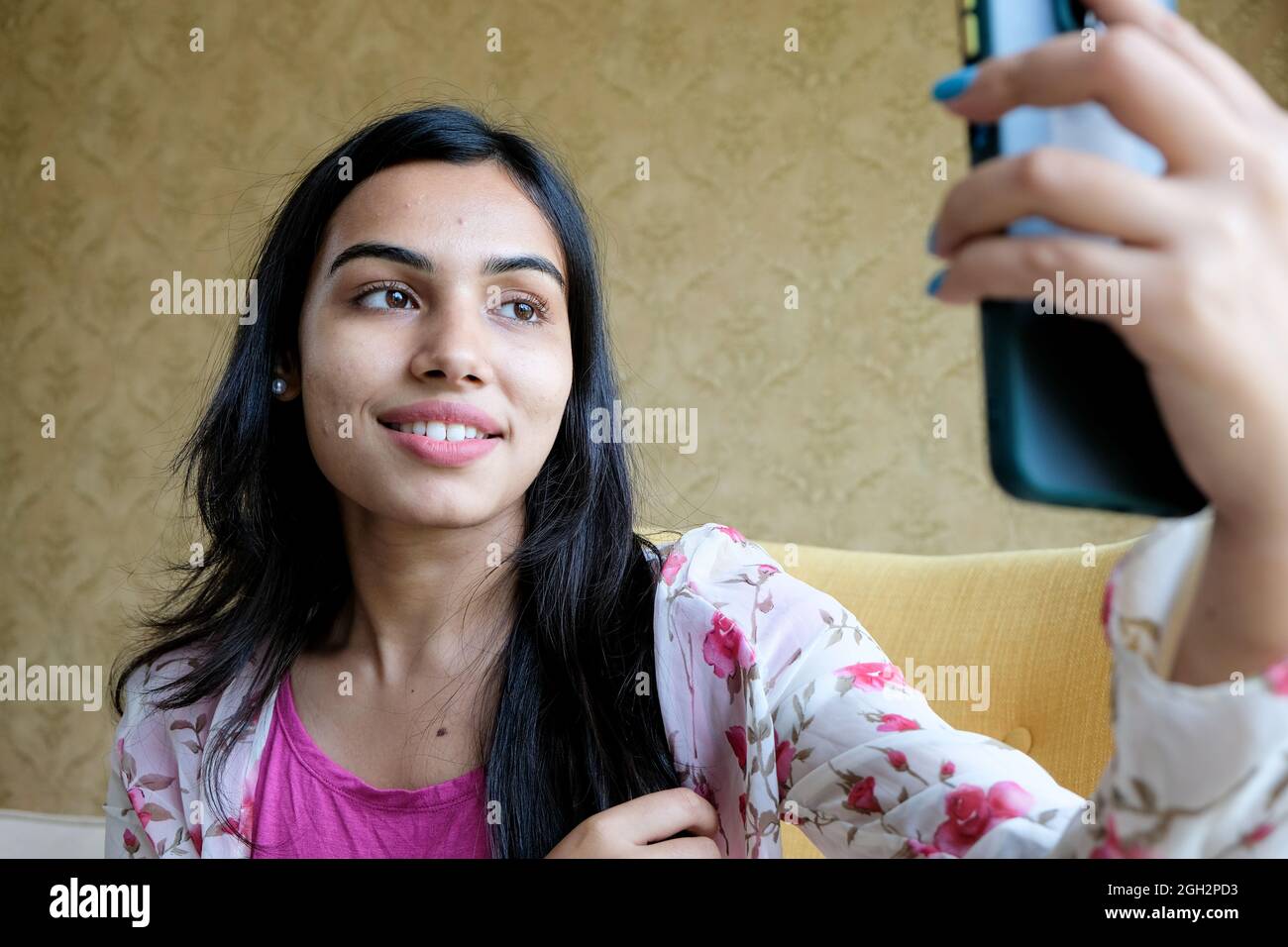Young Indian girl talking on video call with her cell phone at home ...