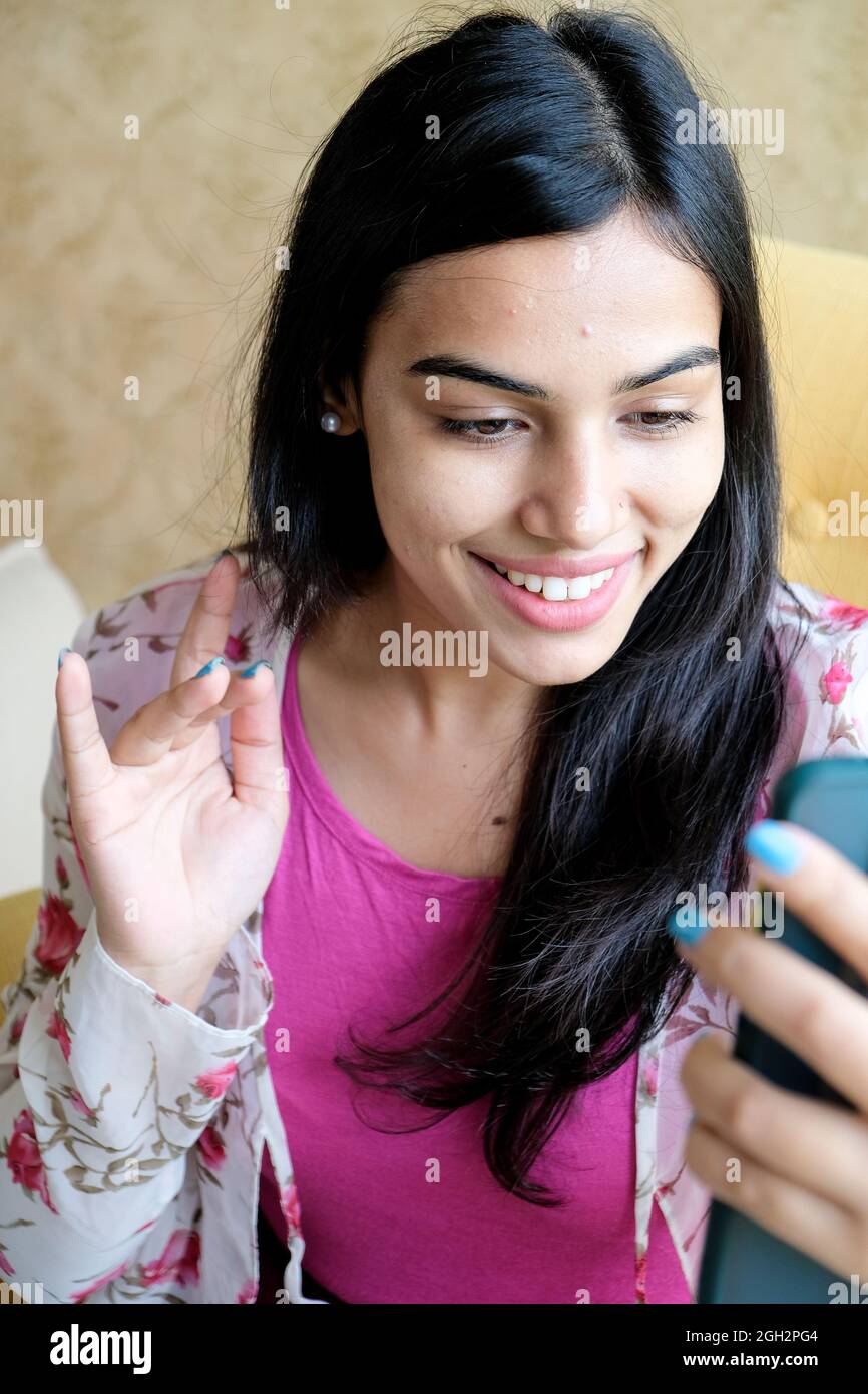 Young Indian girl talking on video call with her cell phone at home ...
