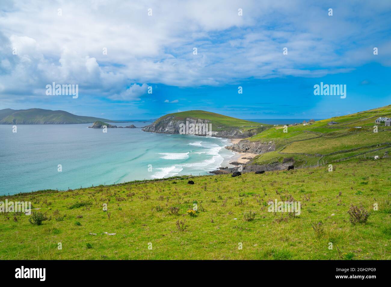 Bay surrounded by road and rock wall and steep dramatic coastal rock ...