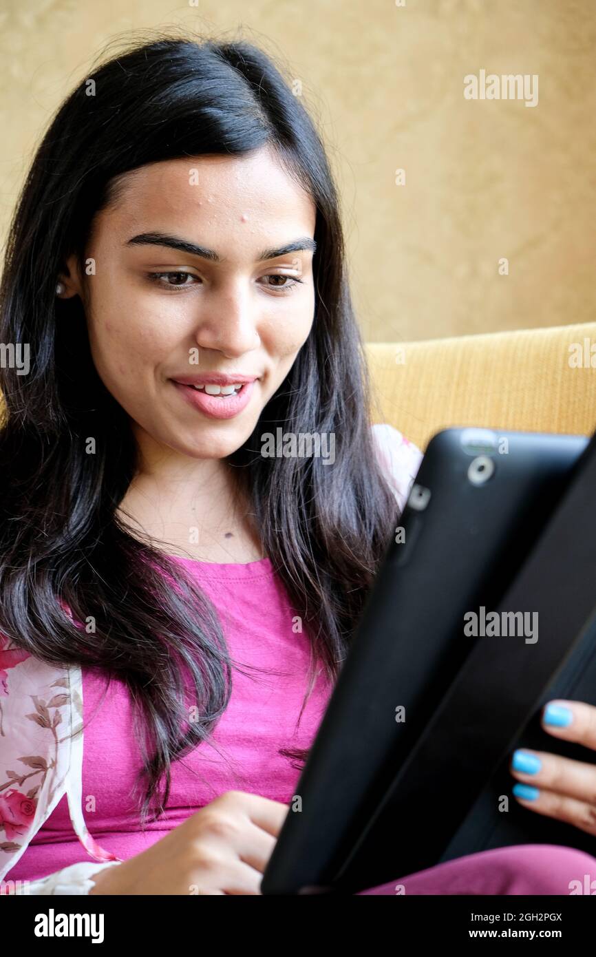 Young Indian girl talking on a video call with her tablet at home Stock ...