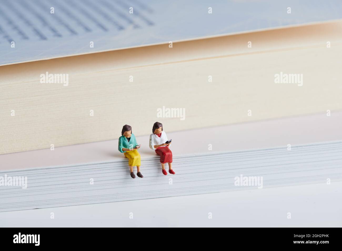 two miniature people reading books Stock Photo - Alamy