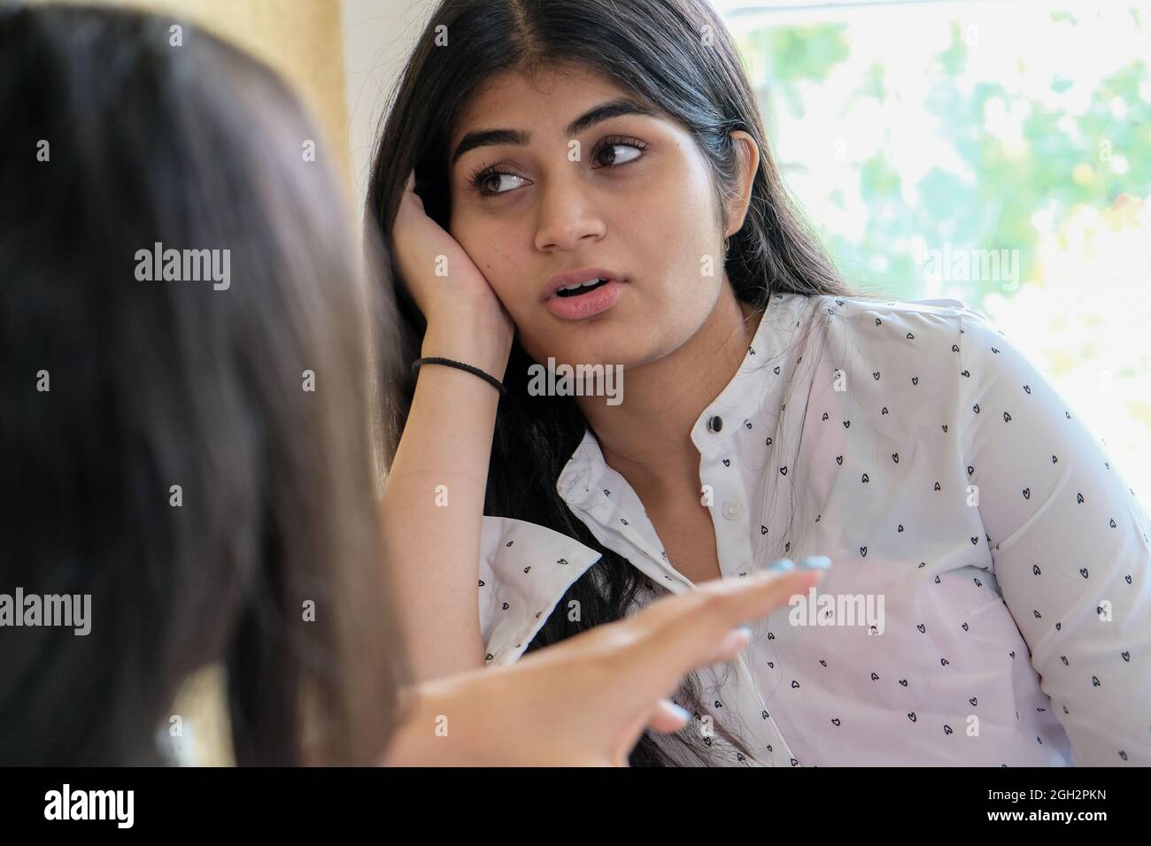 Young Indian girls having a discussion at home Stock Photo - Alamy