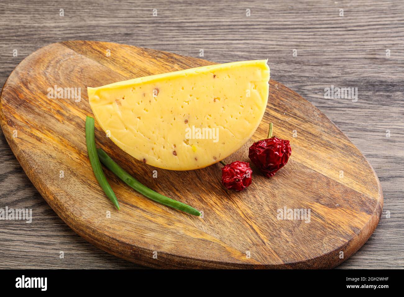 Hard cheese brick with walnut over board Stock Photo - Alamy