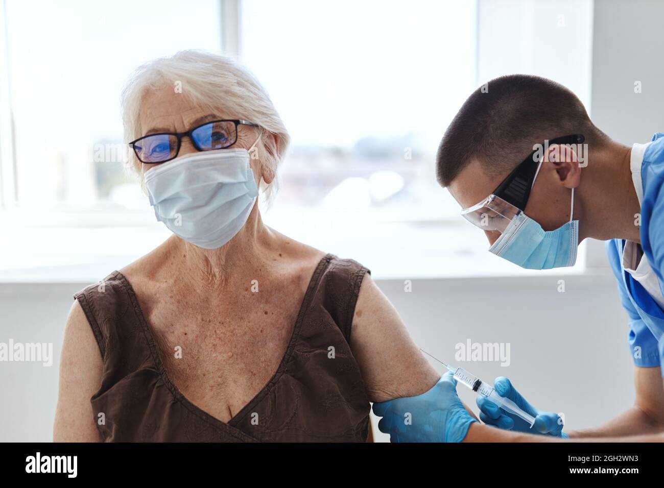 elderly woman next to doctor vaccination hospital immunity protection ...