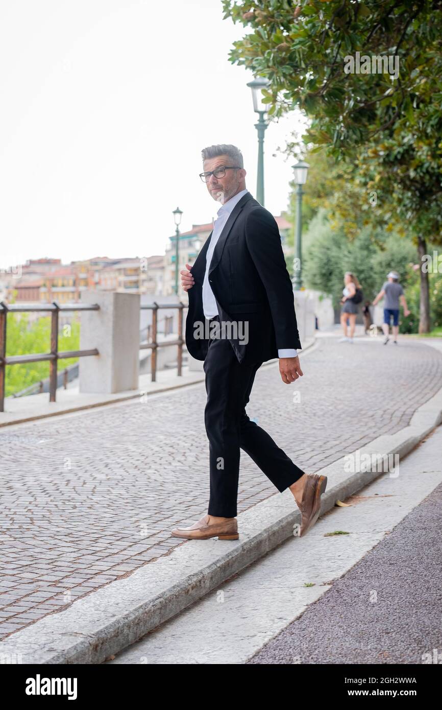 Businessman rushing across the road in a hurry with a jump Stock Photo ...