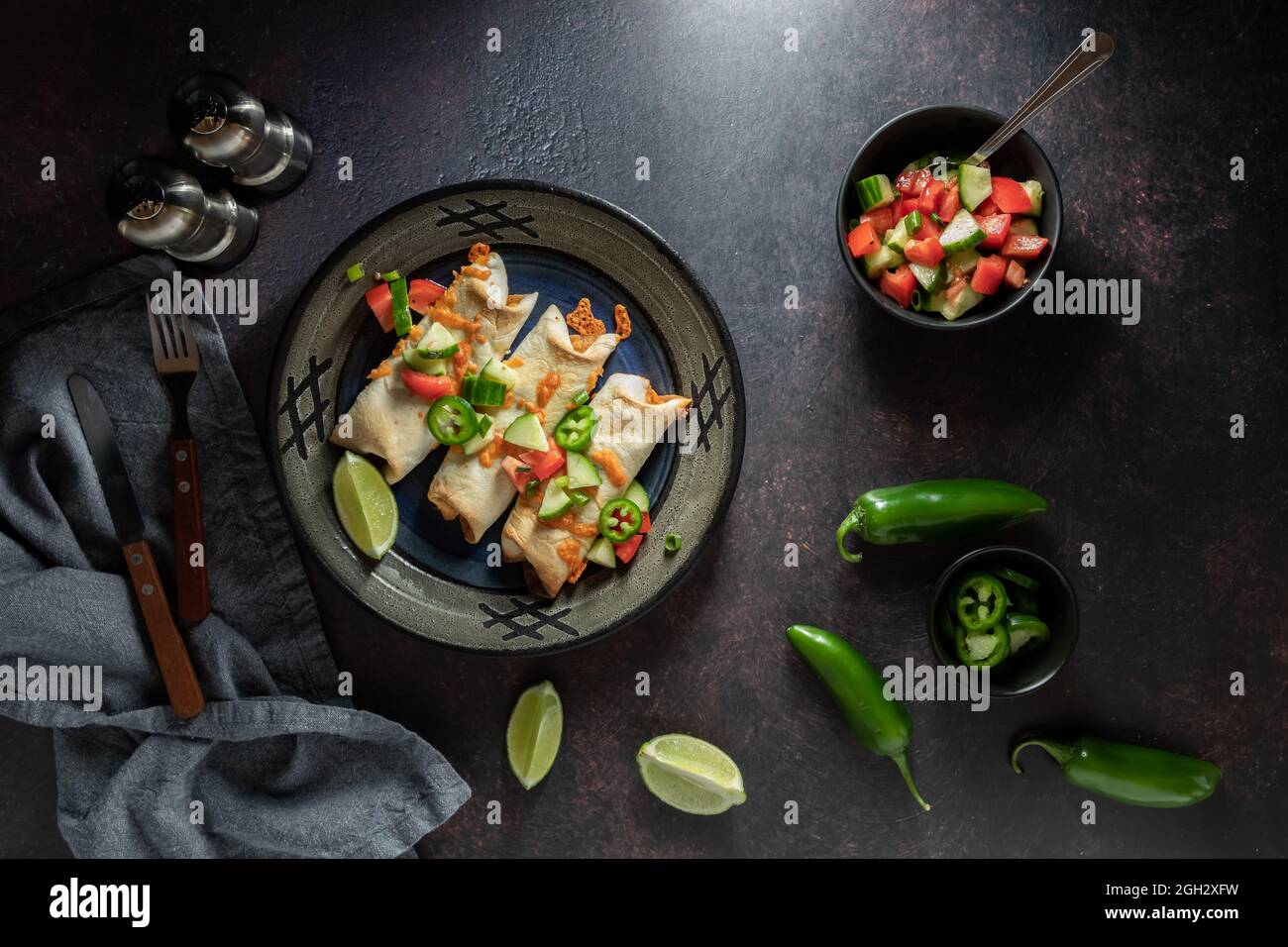 Top down view of taquitos topped with homemade tomato and cucumber ...