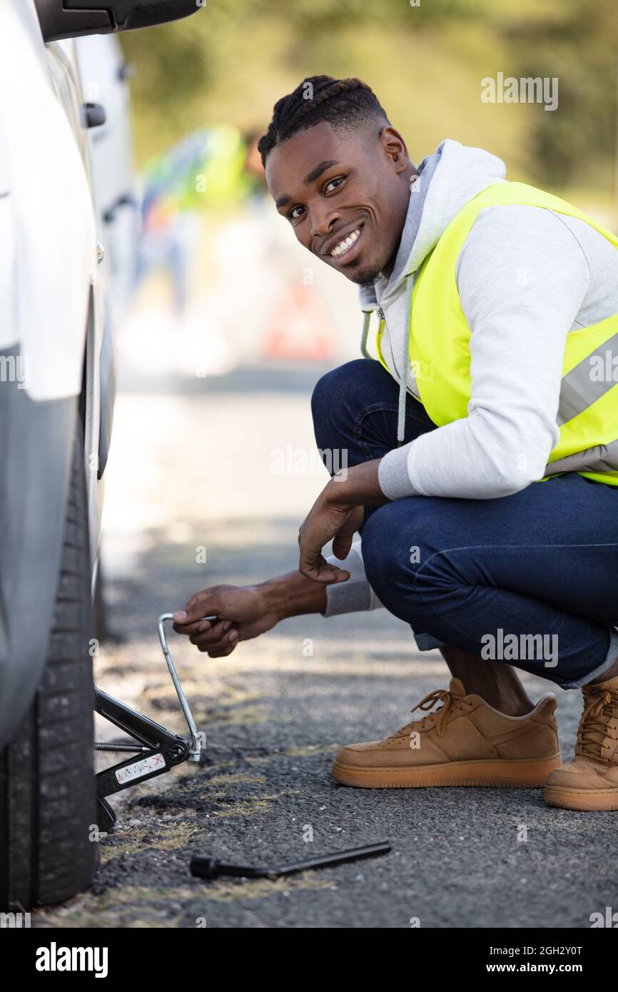 handsome young man lifting the car Stock Photo - Alamy