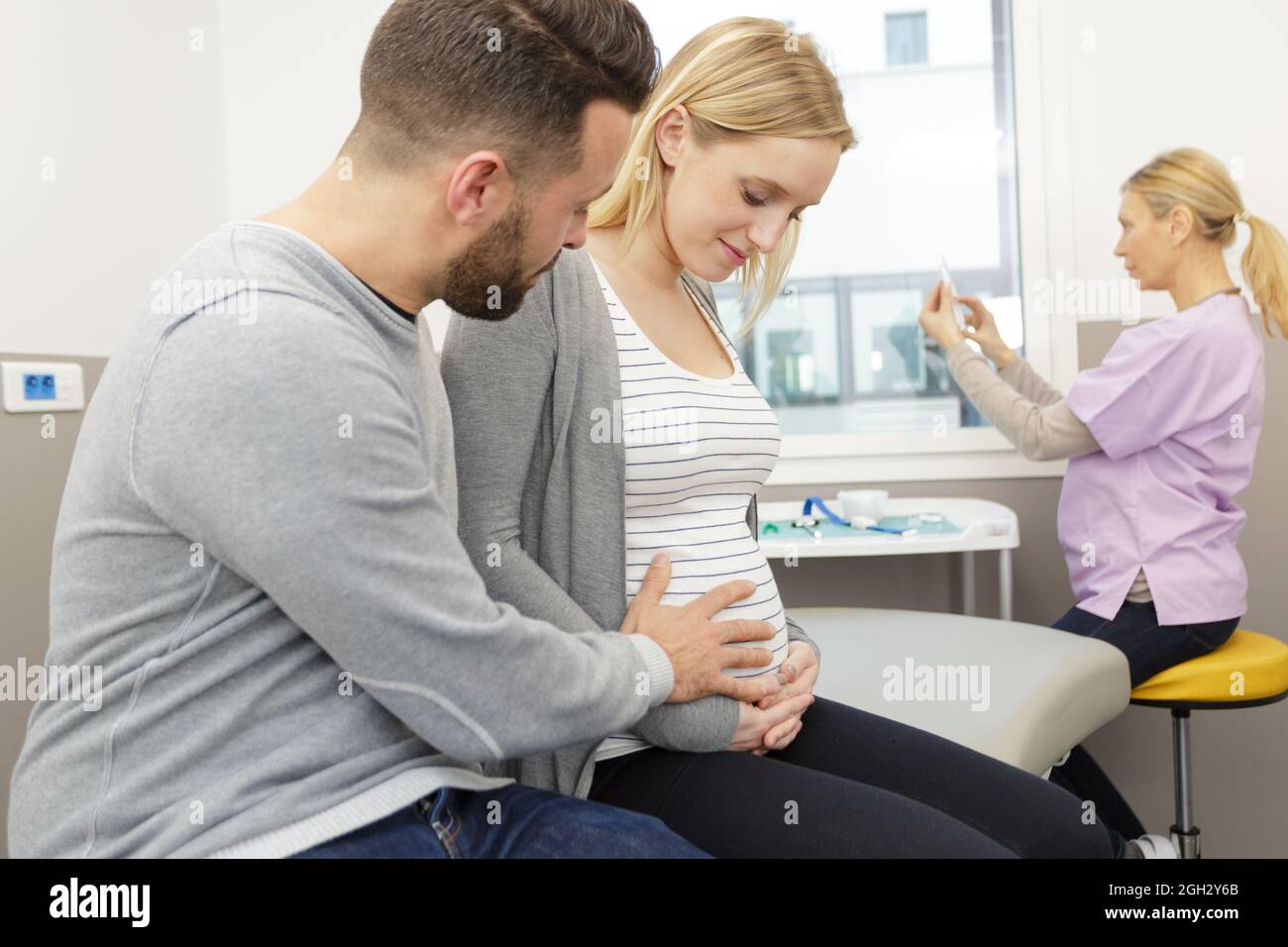 man supporting pregnant wife while nurse prepares injection Stock Photo ...