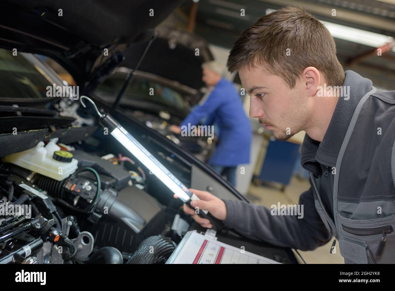 student with instructor repairing a car during apprenticeship Stock ...