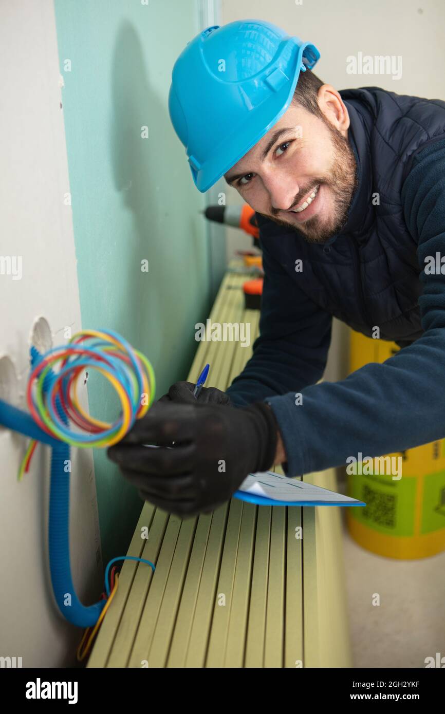 electrician snipping a wire smiling Stock Photo - Alamy