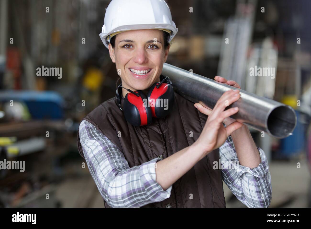 pretty woman next to pipes in factory Stock Photo - Alamy