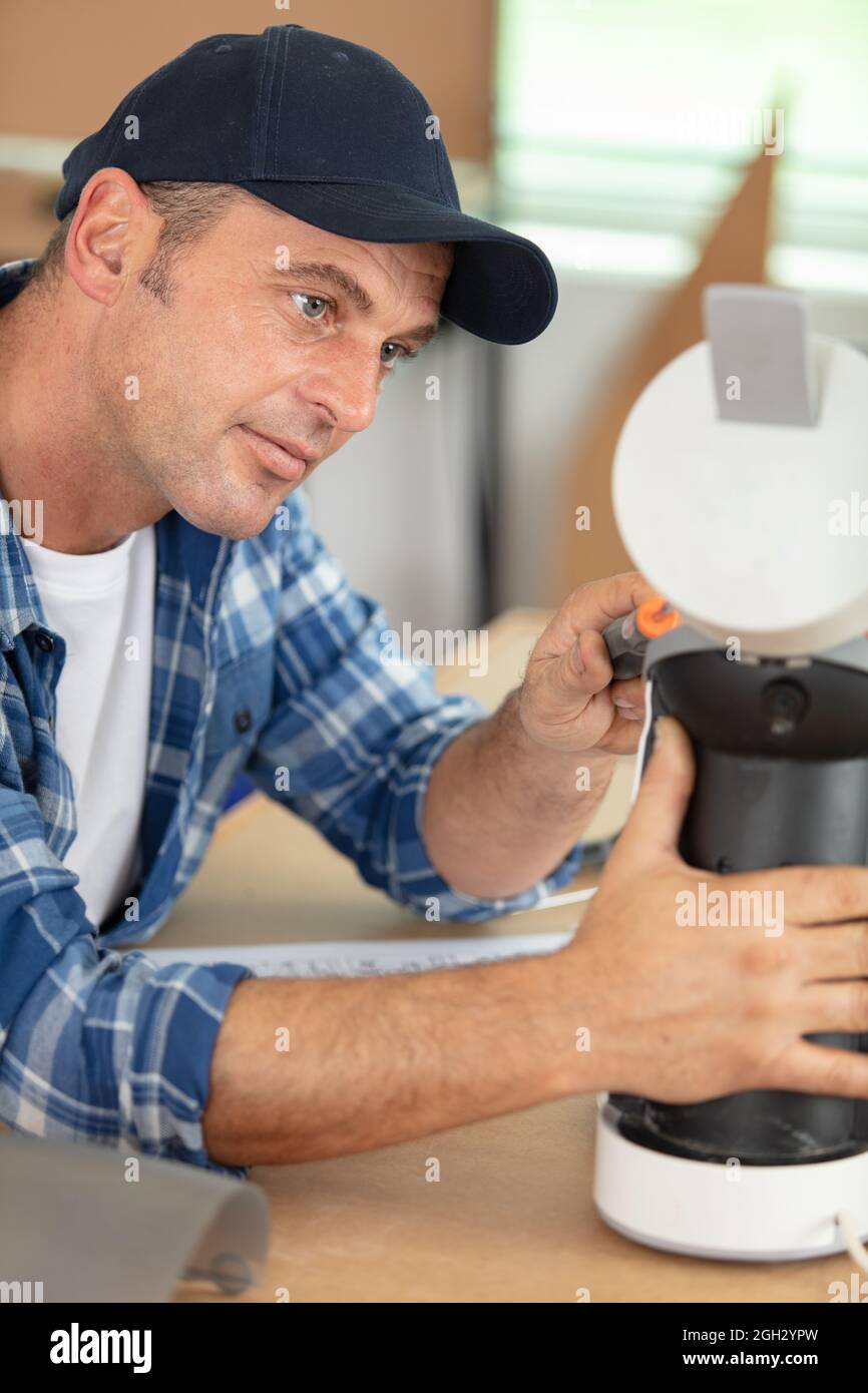 man repairing broken coffee machine Stock Photo - Alamy