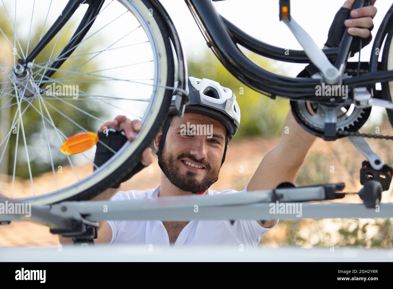 happy cyclist loading on the back of a van Stock Photo - Alamy