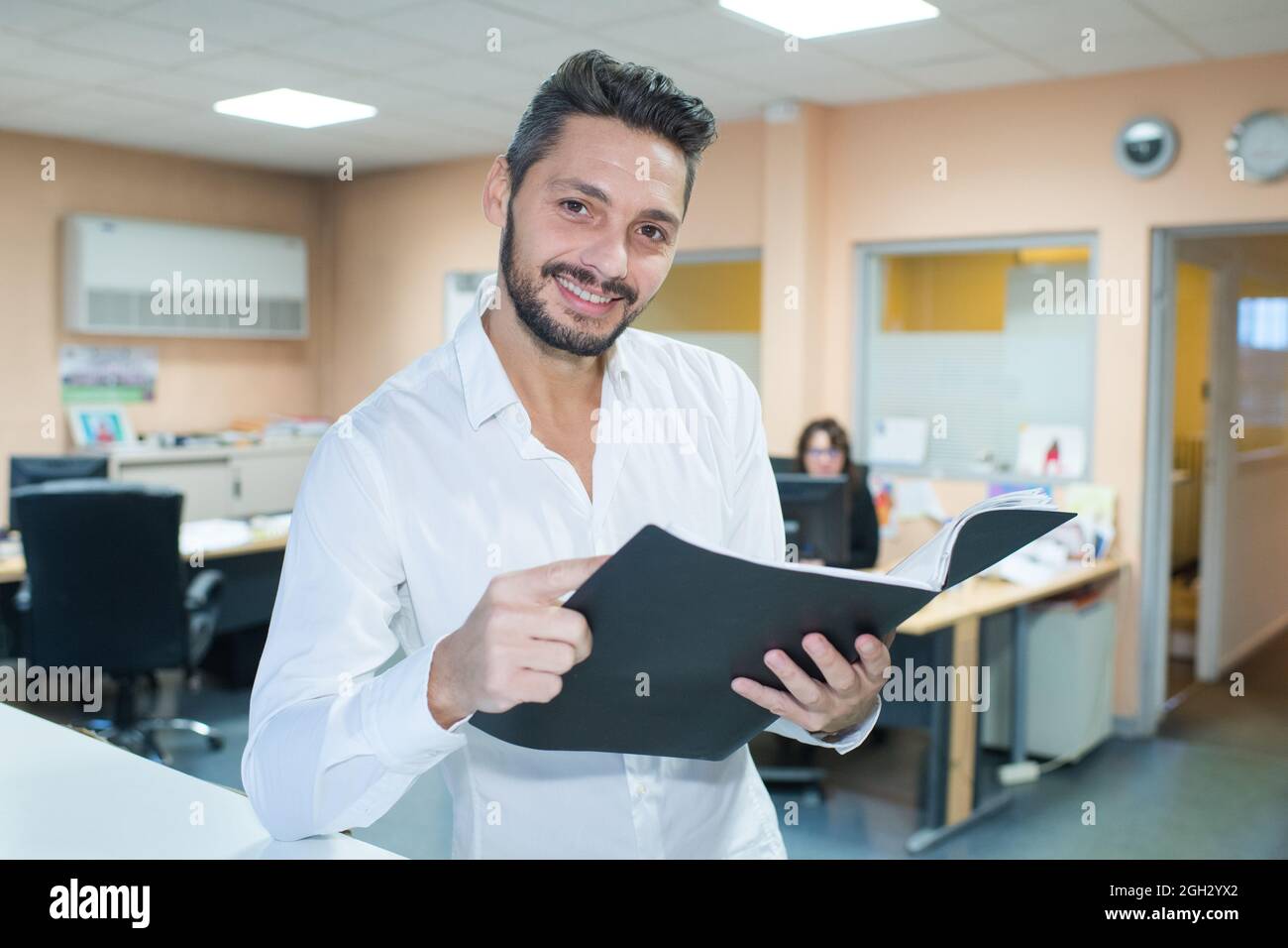 portrait of man looking through file Stock Photo - Alamy