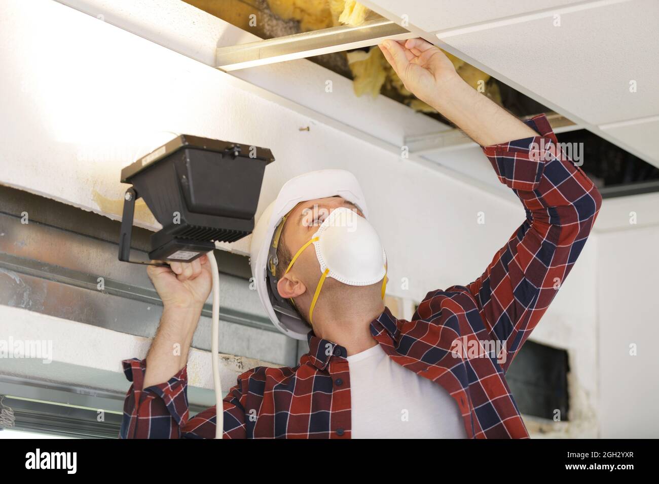 a licensed master checking a hole in the ceiling Stock Photo - Alamy