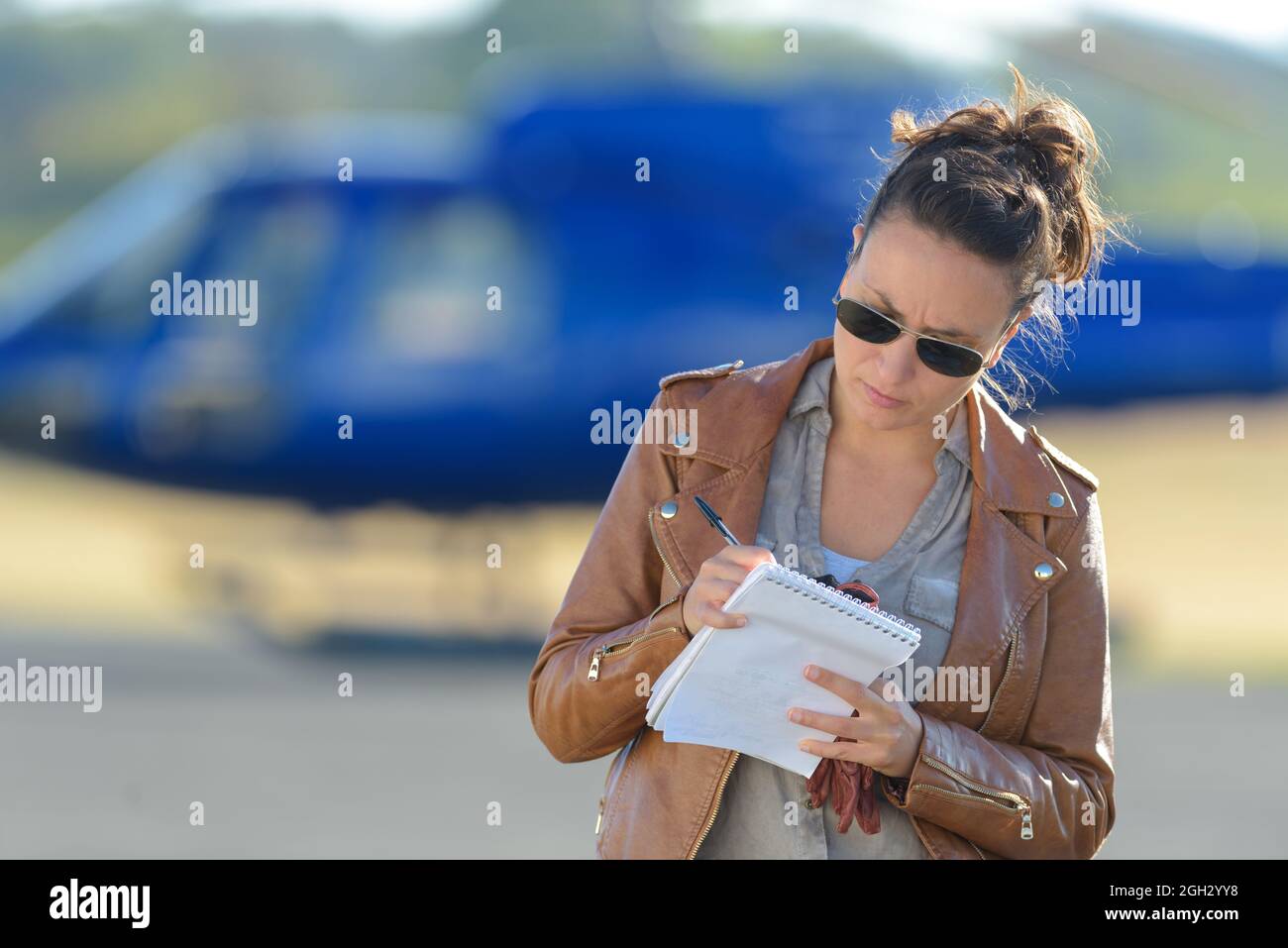 female helicopter pilot taking note Stock Photo - Alamy