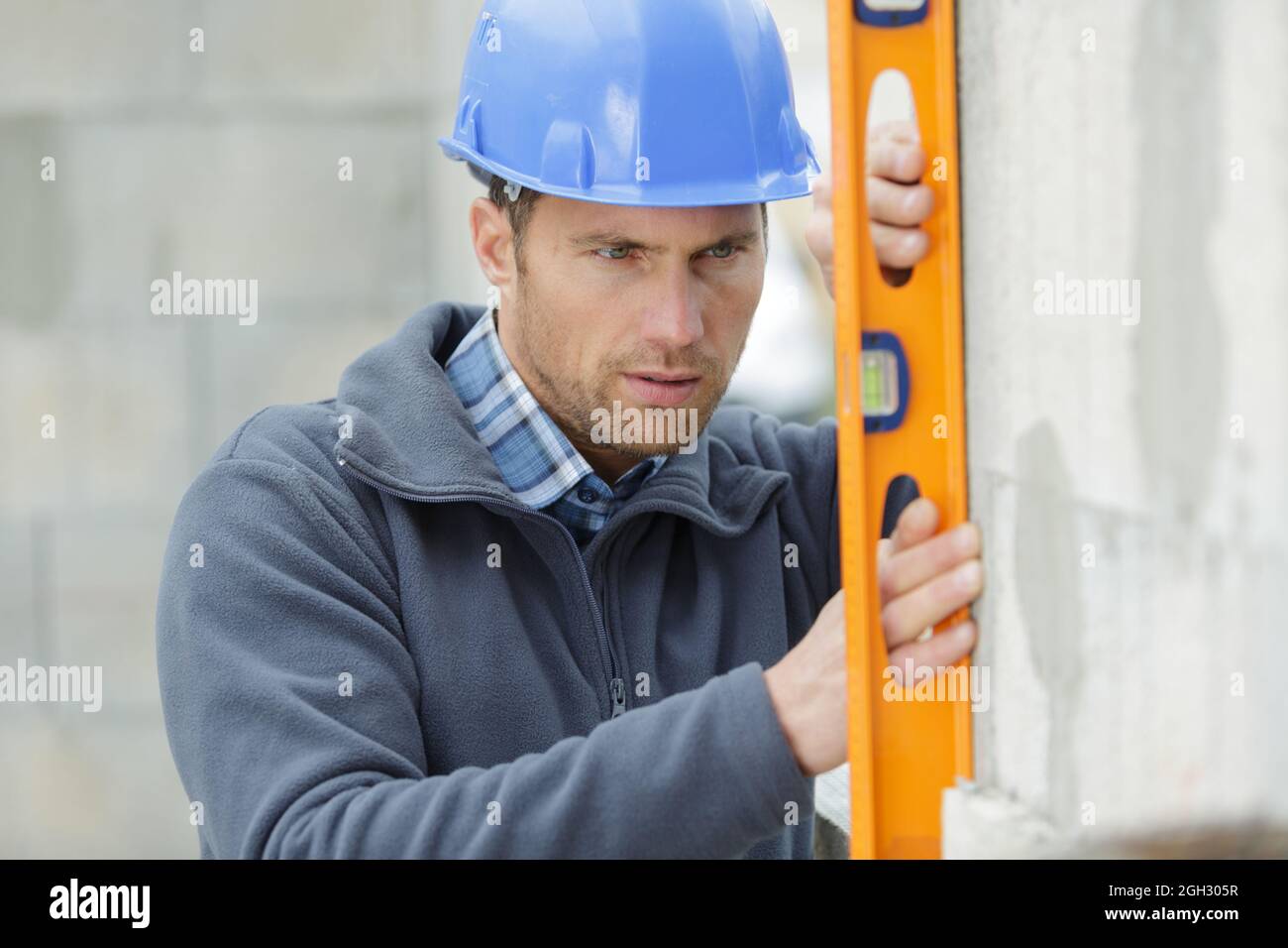 worker with wall with level Stock Photo - Alamy