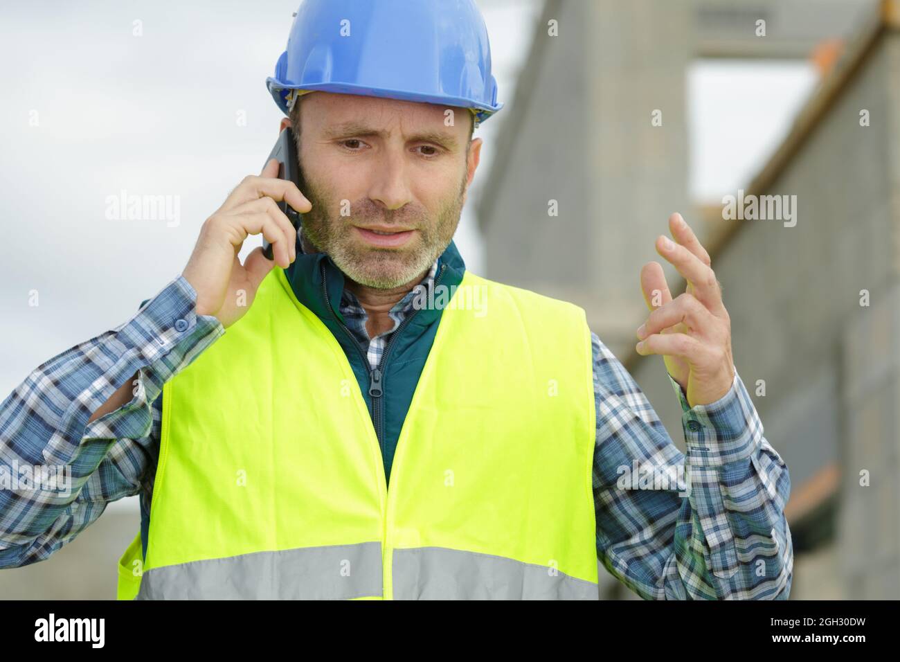 worried construction worker on telephone Stock Photo - Alamy