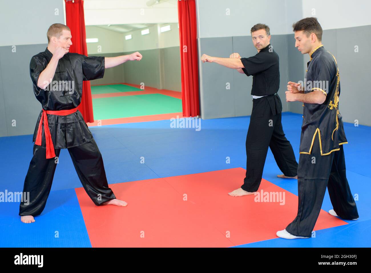 Three men practicing martial arts Stock Photo - Alamy