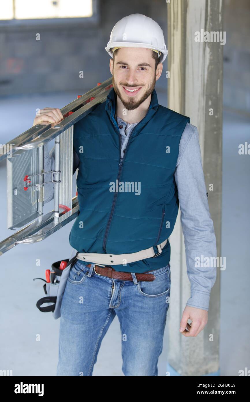carpenter carrying ladder at construction site Stock Photo - Alamy