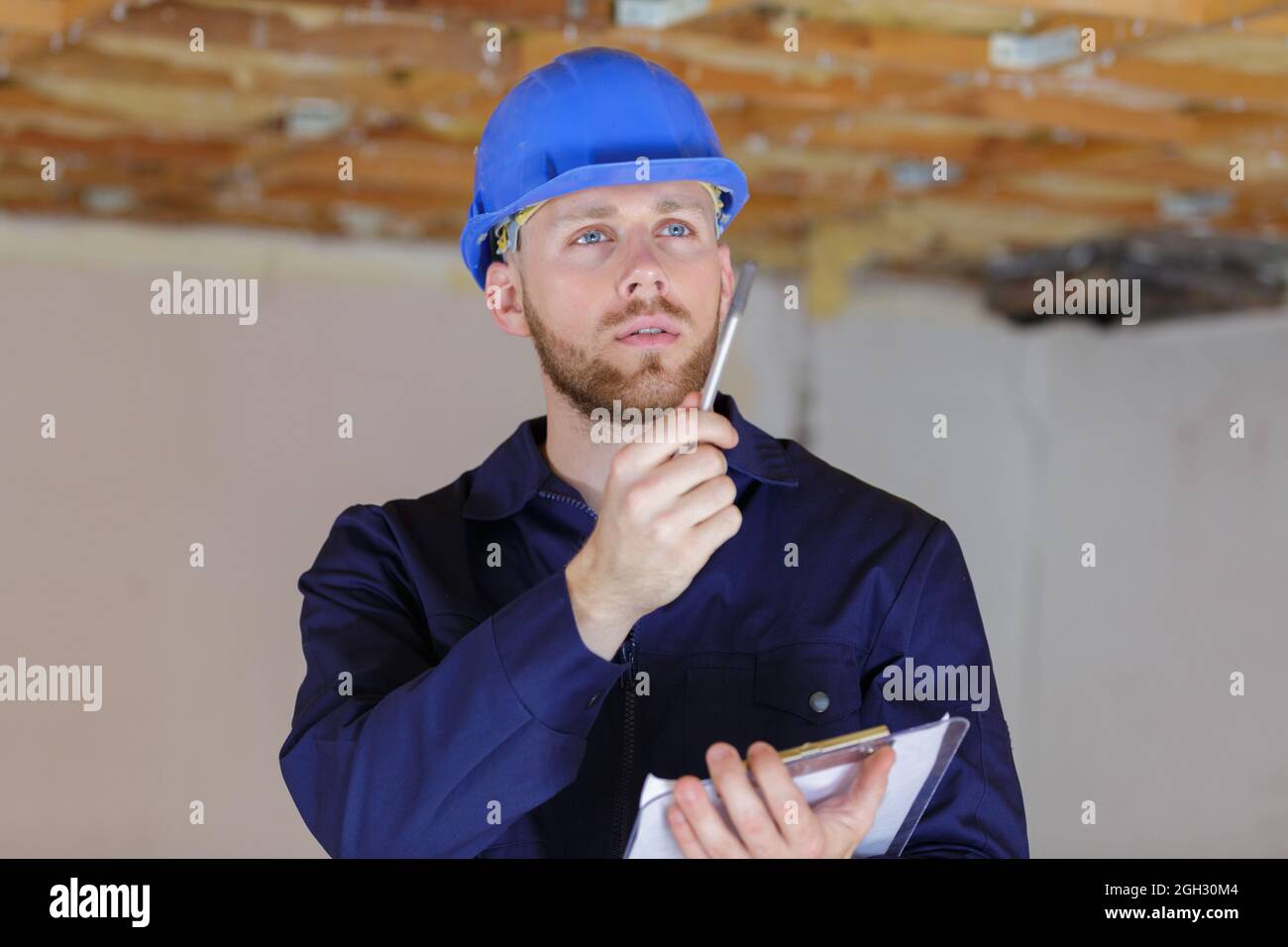 male builder writing on clipboard Stock Photo - Alamy