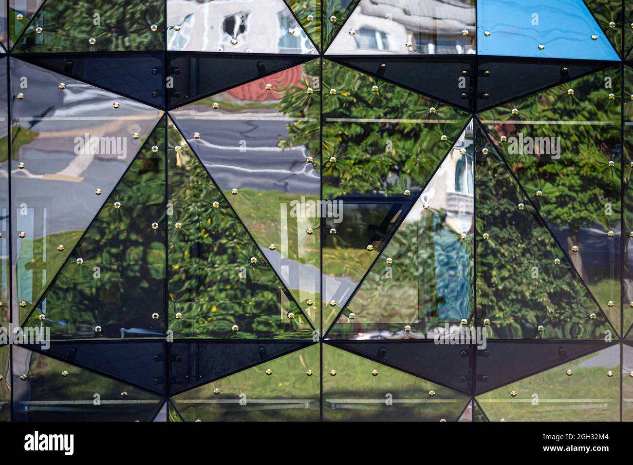 closeup of the glass-clad facade of a modern building covered in ...
