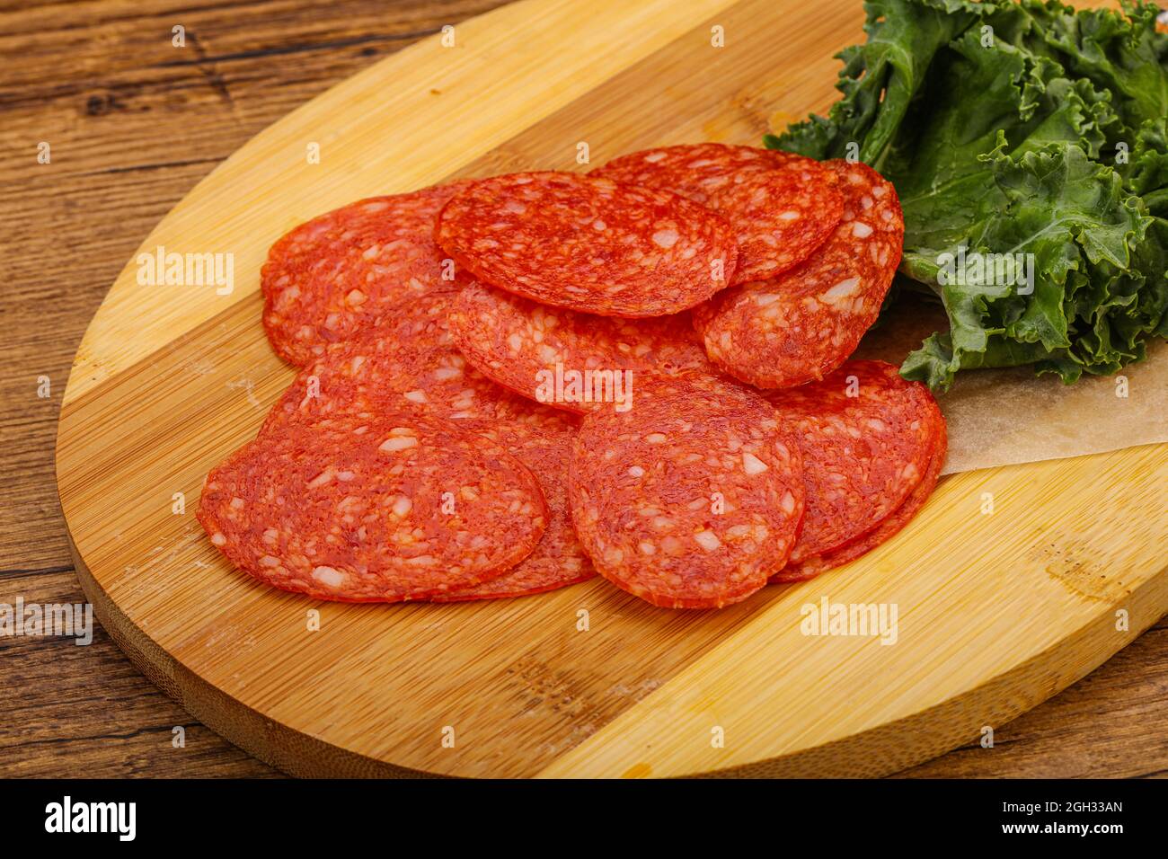 Italian spycy pepperoni sausage slices over board Stock Photo - Alamy