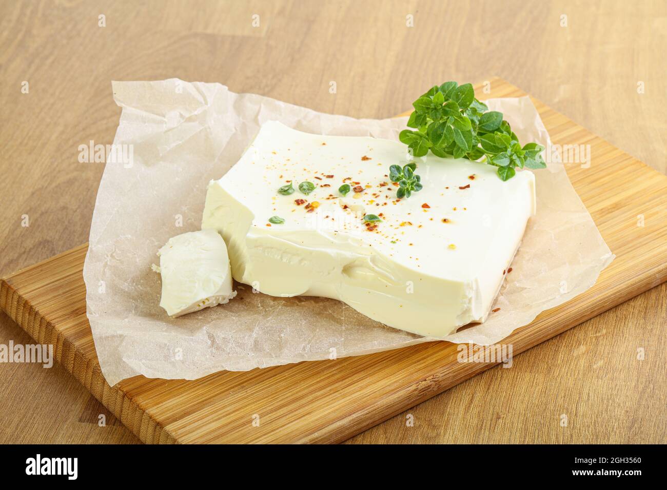 Greek Feta cheese over board served herbs Stock Photo - Alamy