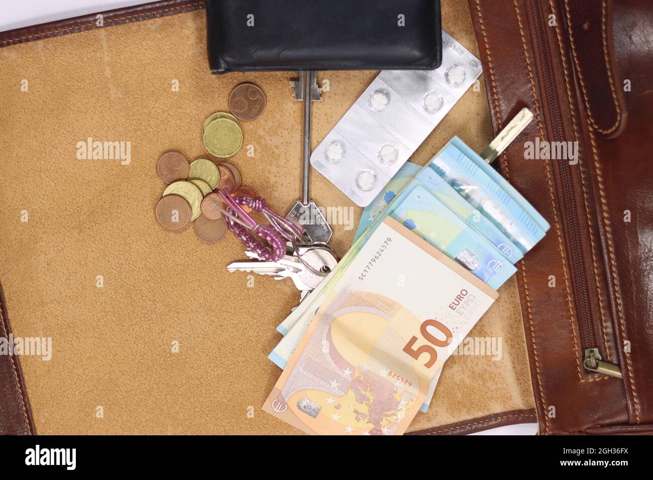 Overhead shot of an open male leather shoulder bag with contents of ...