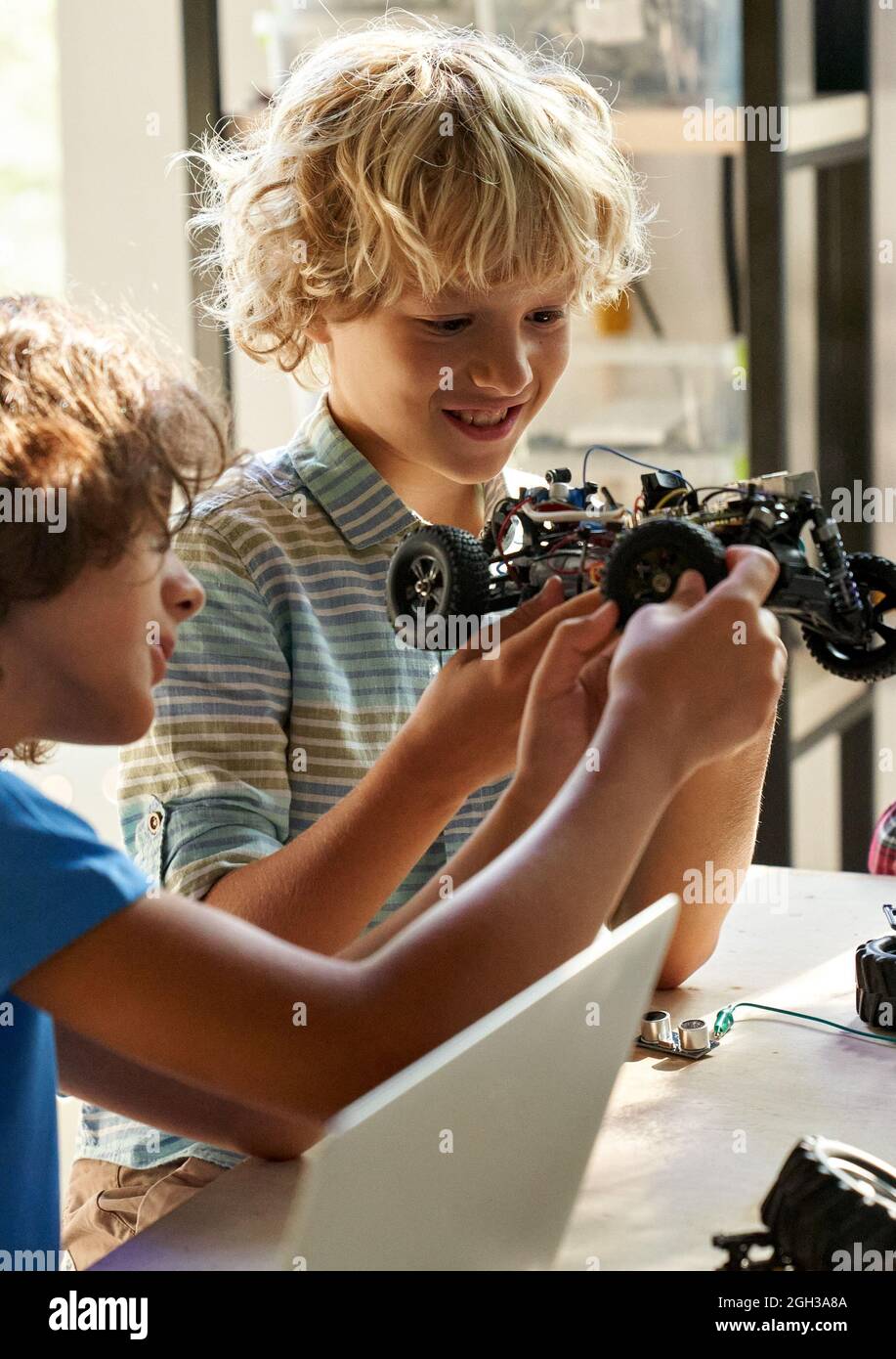 School kids boys helping building robotic car learning together at STEM ...