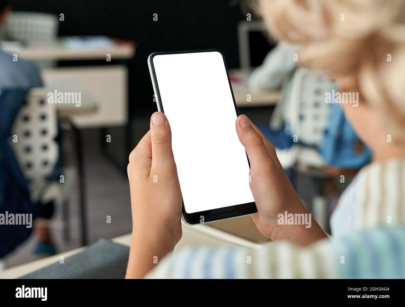 Kid boy junior school student using phone with mockup screen in ...