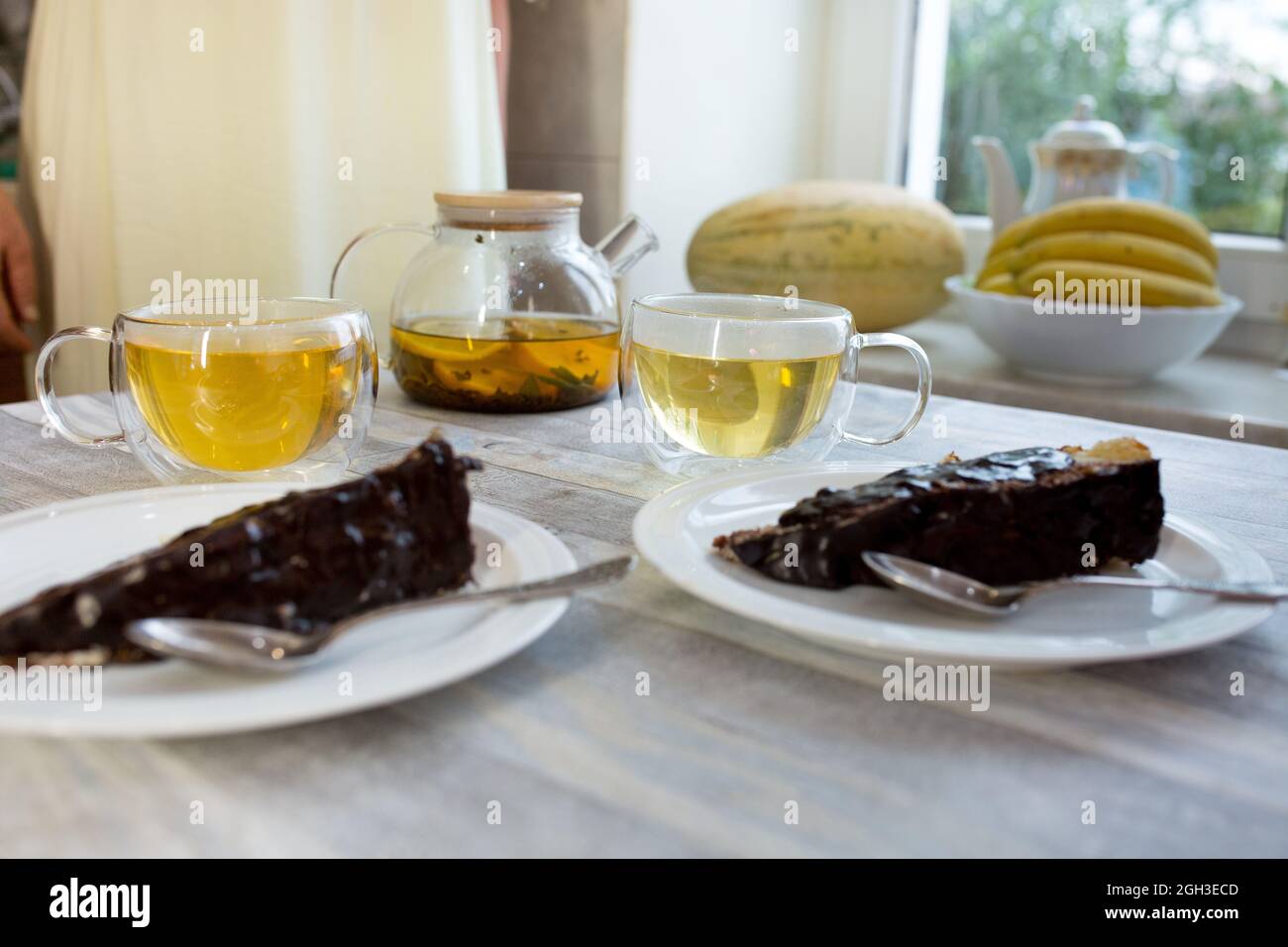 Afternoon tea. Teapot with mint and lemon brewed tea, cups and homemade ...
