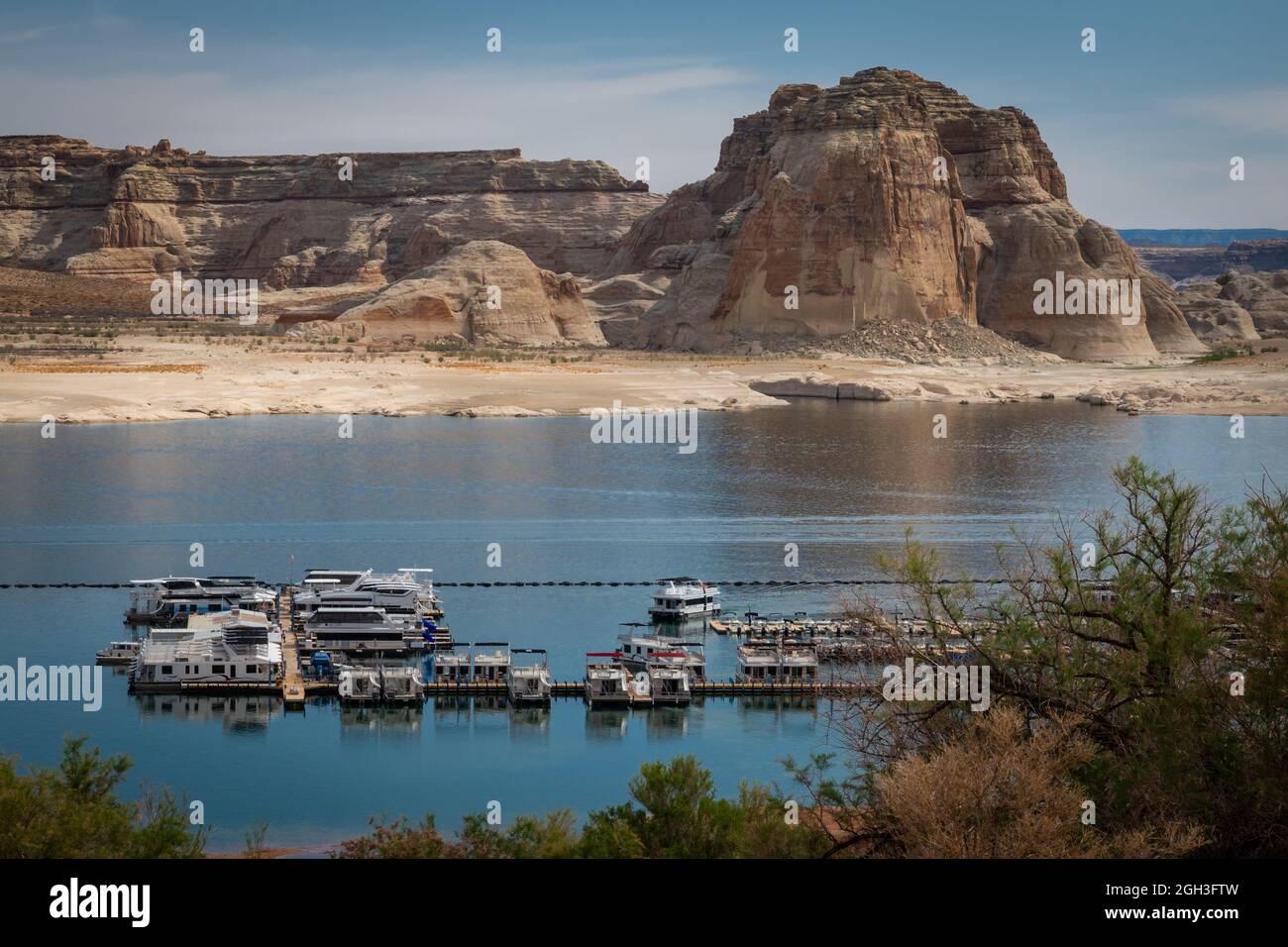 Boats docked on Lake Powell, Utah with sandstone cliffs and beach in ...