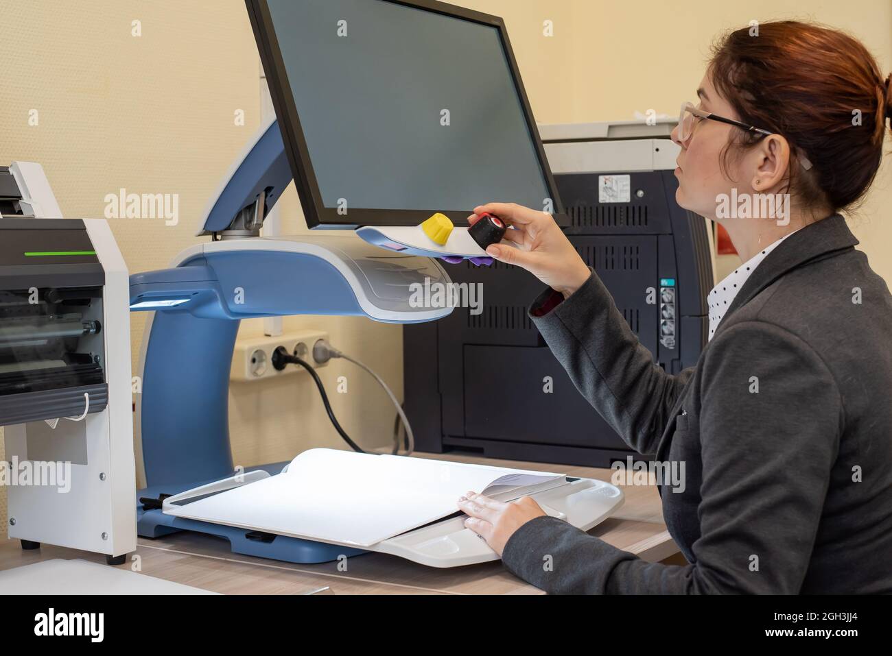 A visually impaired woman uses special reading equipment Stock Photo ...