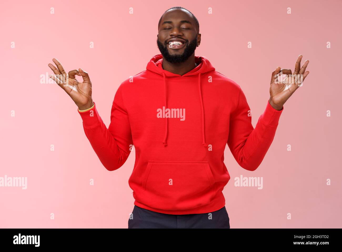 Happy african american bearded man in red hoodie meditating found peace ...