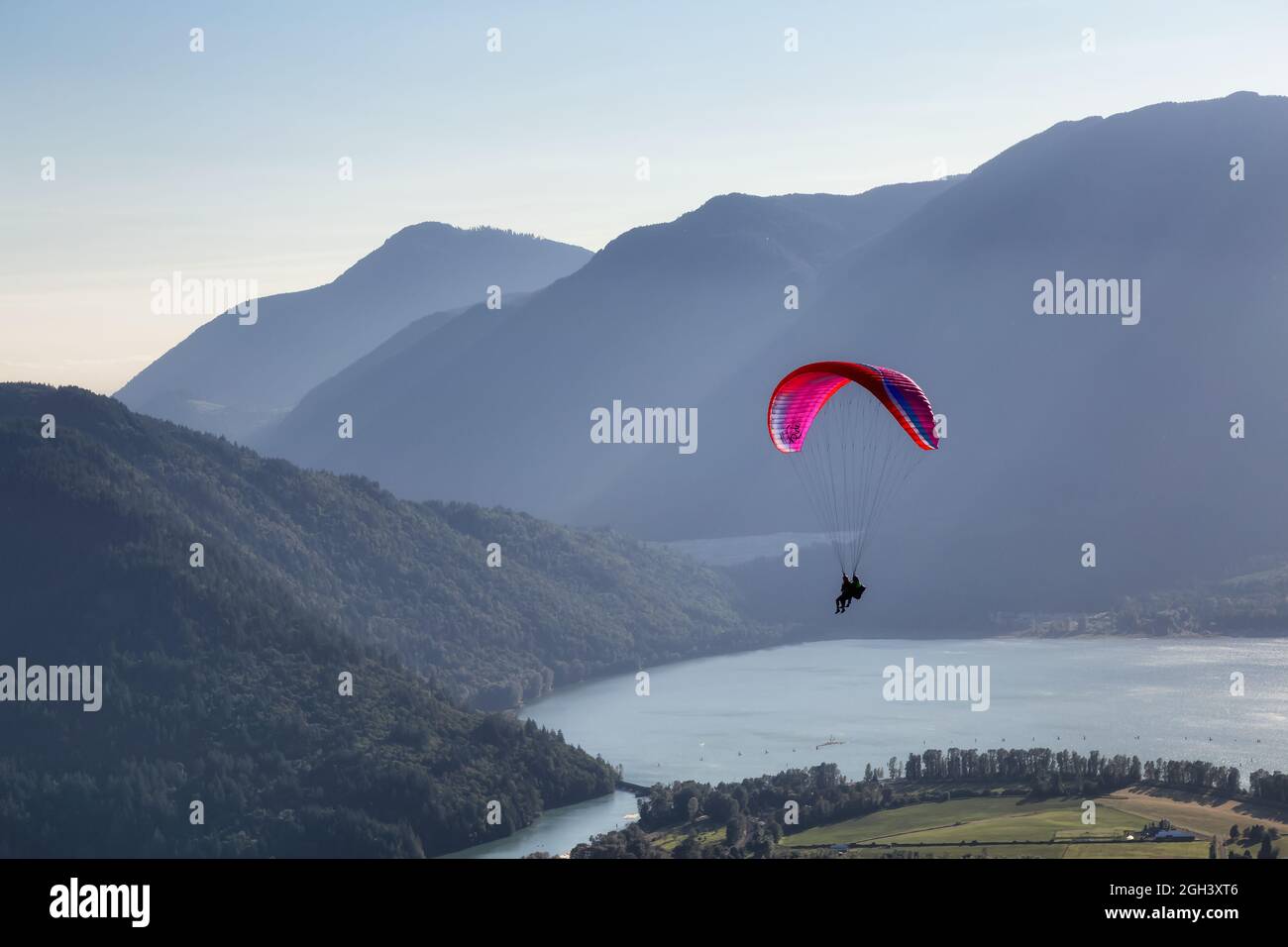 Adventurous people Paragliding around the Canadian mountains Stock ...